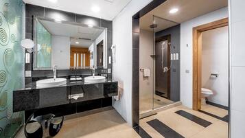 Casa de banho moderna com duas pias, um espelho grande e zona de duche.