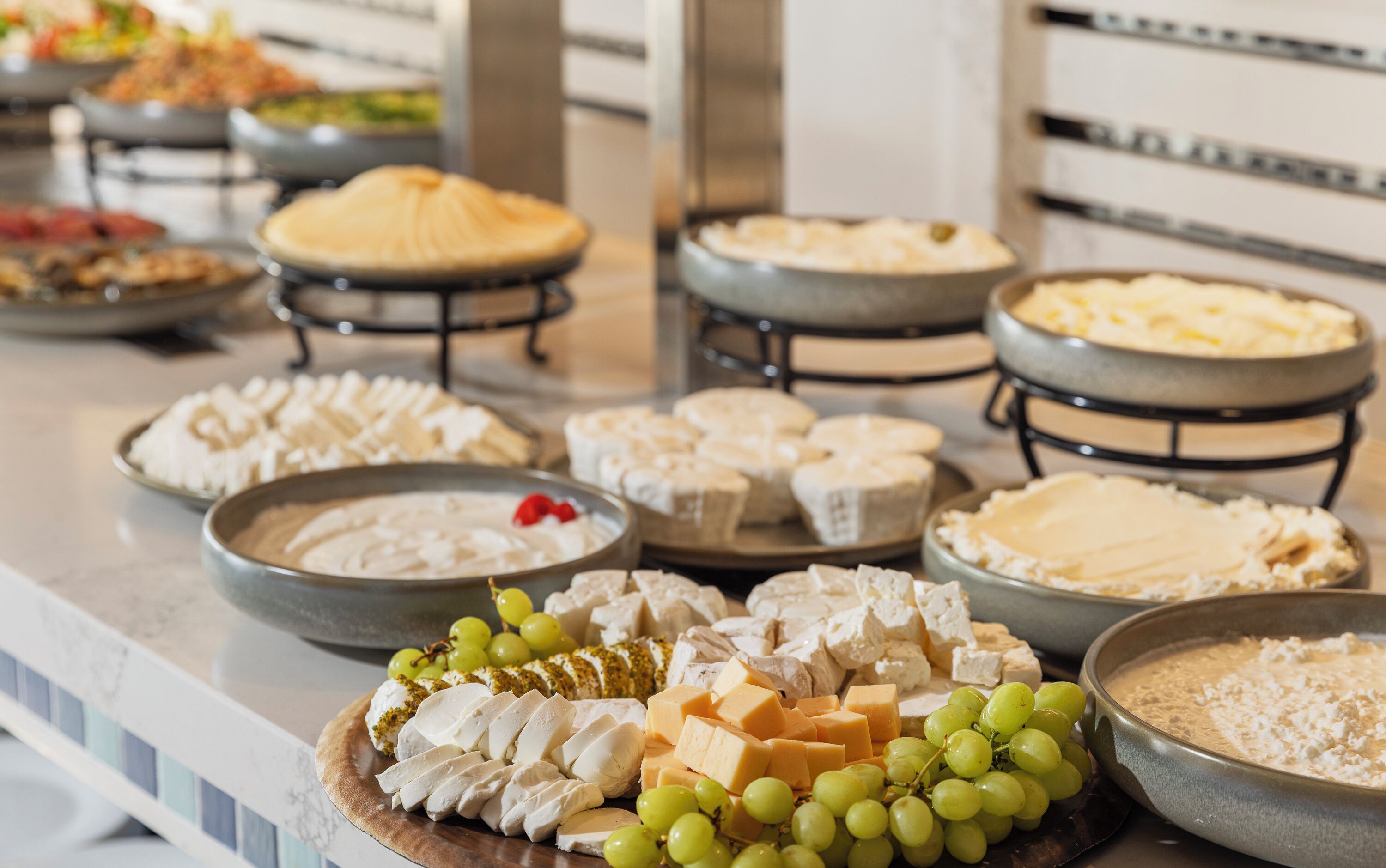 Buffet com diversos queijos e frutas.