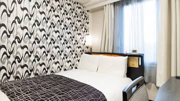 Quarto de hotel com papel de parede estampado, cama com roupa de cama branca, mesa de cabeceira com abajur, painel de controle e janela com cortinas.