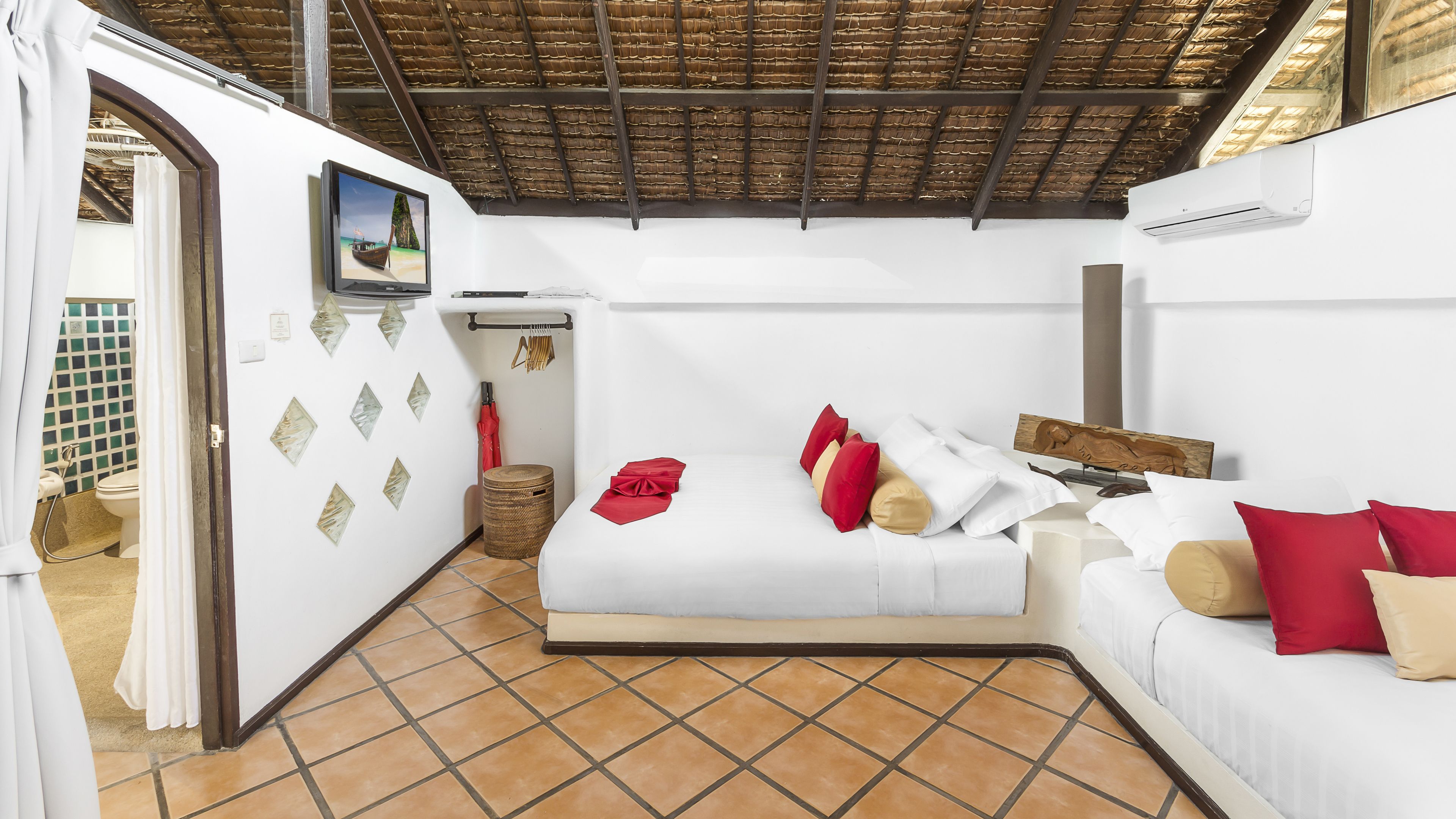 Quarto com cama, televisão, ventoinha no teto e janela.