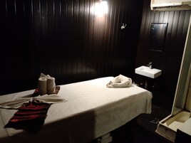 Quarto de hotel com uma cama, uma pia de banheiro branca e um porta-toalhas.