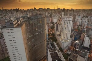 Paisagem urbana com edifícios altos, um arranha-céu curvo e um ambiente urbano denso.