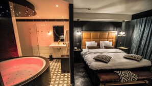 Quarto de hotel moderno com uma cama grande, banheiro privativo com hidromassagem e área de chuveiro separada.