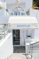 Uma área de recepção com um toldo branco e uma placa com a inscrição 'RECEPTION'.
