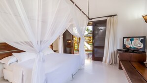 Quarto com cama, televisão e vista para o exterior.