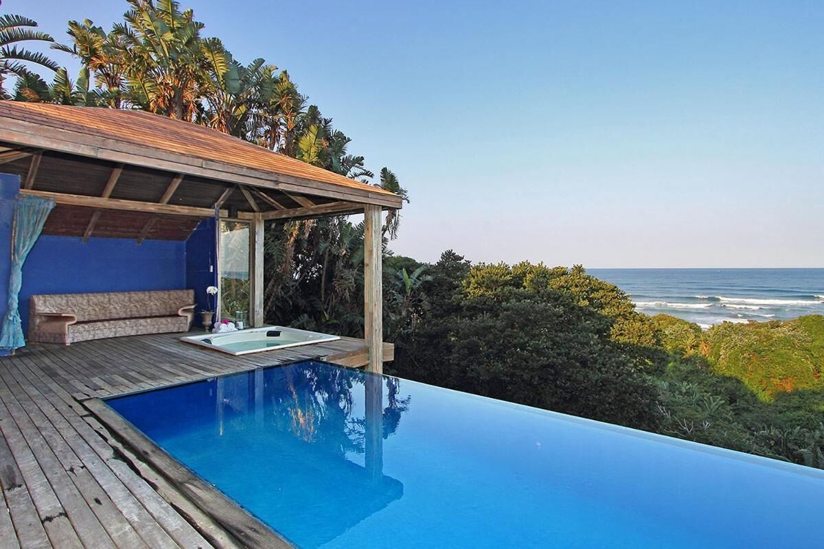 Piscina externa, piscina infinita, guarda-sóis, espreguiçadeiras