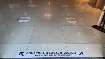 Piso com placas de sinalização e indicação para aguardar no local indicado.