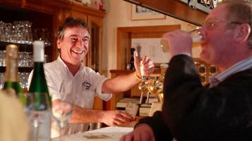 Um bar com um bartender servindo uma bebida a um cliente.