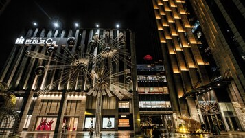 Um edifício moderno com uma grande escultura iluminada em frente.