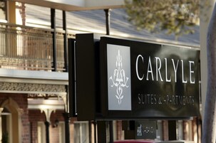 Placa para 'Carlyle Suites & Apartments' com logotipo e nome.