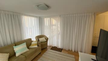 Penthouse, 3 quartos, vista para o oceano | Sala de estar | TV de ecrã plano