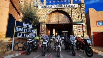Hotel e restaurante chamado "Hotel Restaurant La Kasbah", com fachada de pedra e entrada em arco.