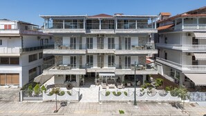 Um hotel com vários andares, varandas, área de estar externa e um pátio central.