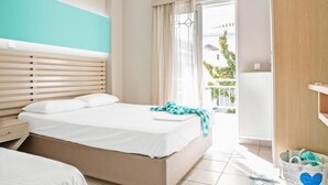 Quarto de hotel com uma cama, mesa de cabeceira, janela com cortinas e vista para o exterior.