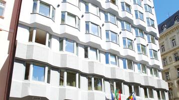 Um hotel de vários andares com design arquitetônico moderno, com uma série de varandas e grandes janelas.