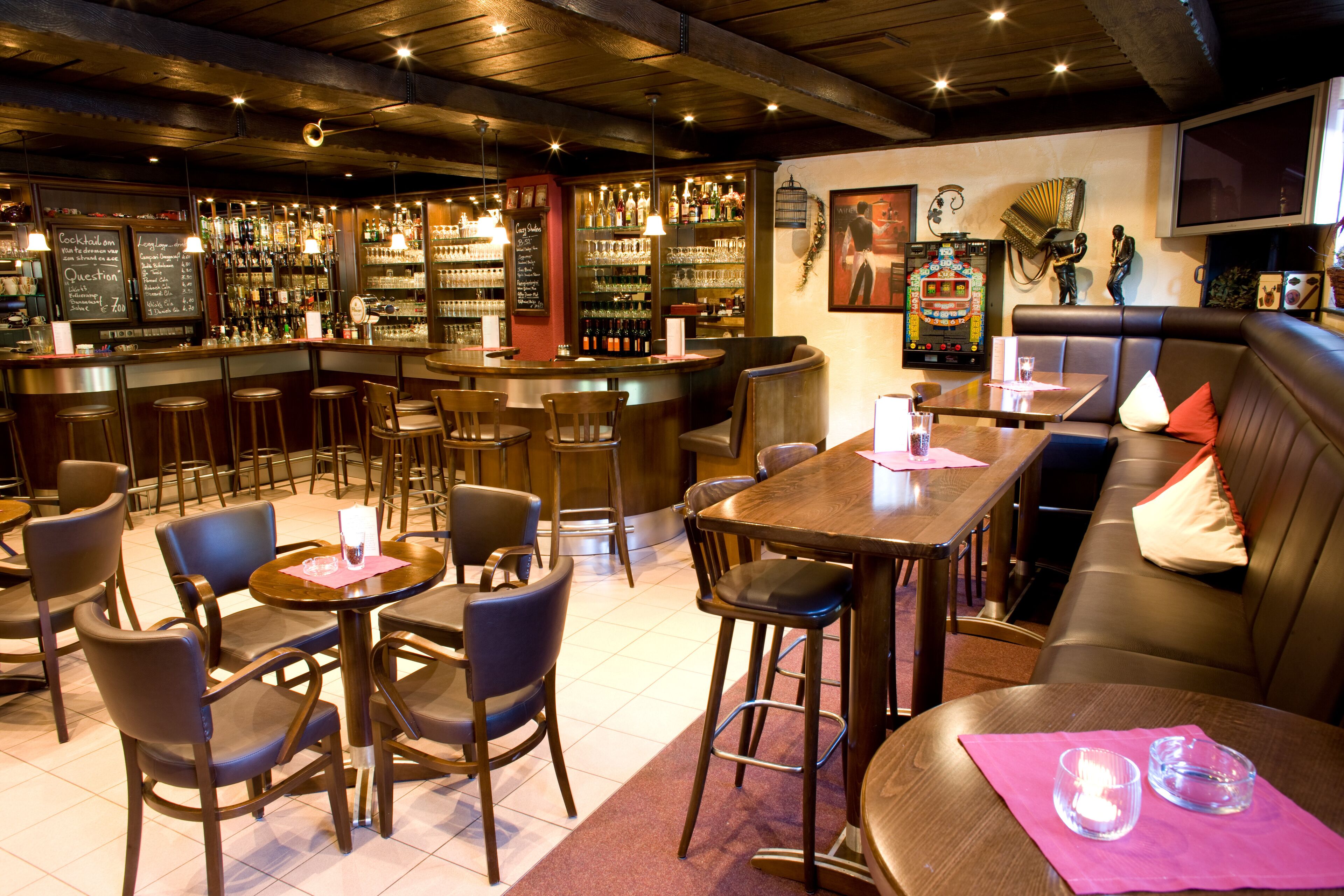 Uma área de bar com bancos, mesas e balcão.