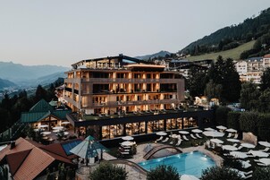 Um hotel com vários andares, área de estar ao ar livre e piscina.
