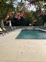 Área de piscina com espreguiçadeiras e uma piscina.