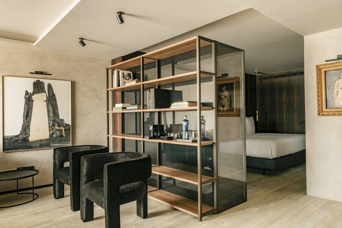 Quarto moderno com estante de vidro, uma cama, uma escrivaninha e uma cadeira.