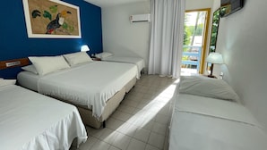 Quarto de hotel com três camas, um quadro na parede azul, um aparelho de ar condicionado e uma TV na parede.
