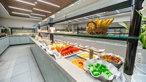 Buffet com diversos alimentos e uma vitrine de vidro.