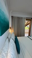 Quarto de hotel com cama, cortinas e vista para o exterior.