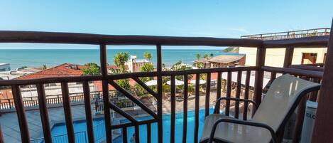 Varanda com vista para uma piscina e o oceano.