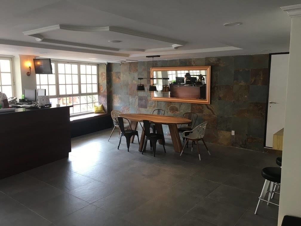 Cozinha moderna com área de jantar, painel de parede em pedra e uma grande janela que traz luz natural.