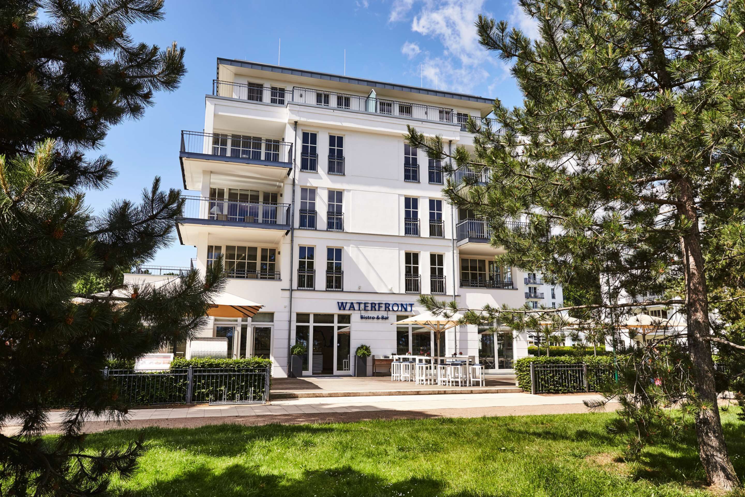 Um hotel de vários andares com fachada branca, varandas e uma placa com a inscrição 'Waterfront Bistro & Bar'.