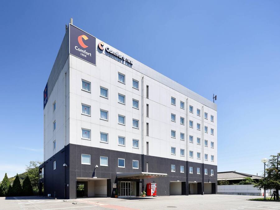 Um hotel Comfort Inn com design moderno, apresentando uma entrada ampla e várias janelas.