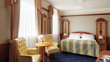 Quarto de hotel com cama, cadeira, mesa e abajur.