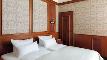 Quarto de hotel com cama grande, cabeceira de madeira e porta com espelho.