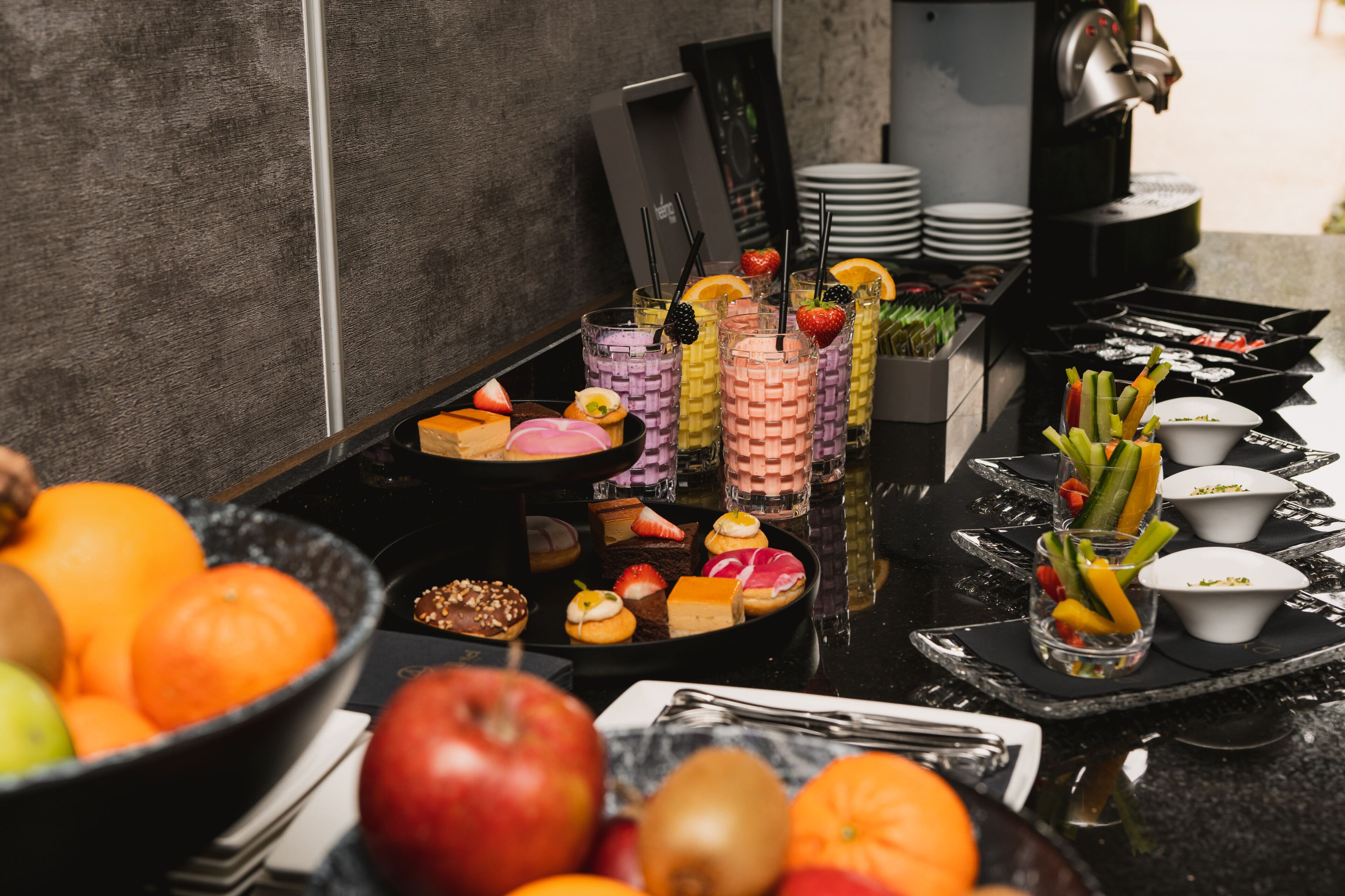 Buffet com diversas frutas, sobremesas e bebidas.