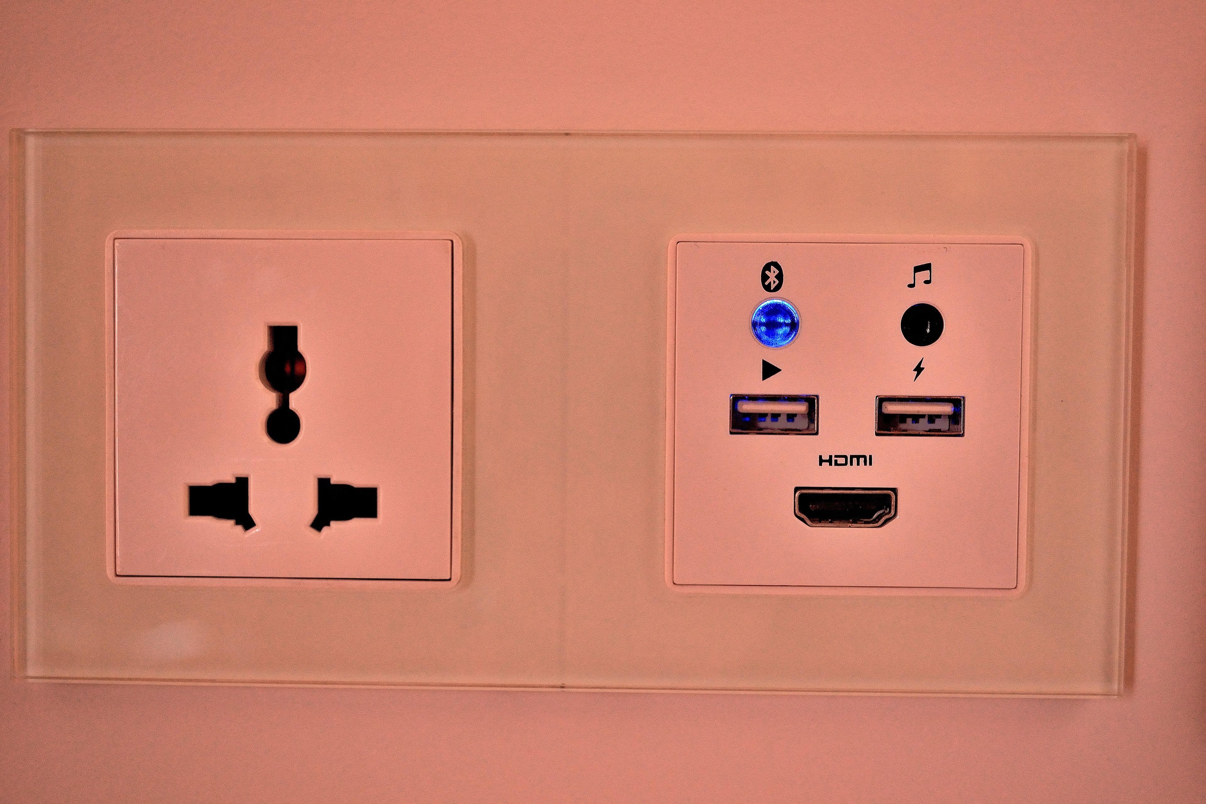 Painel de controlo fixado na parede, com vários botões e portas, incluindo uma porta USB e HDMI.