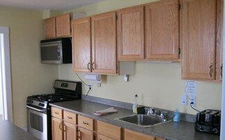 Um frigorífico, um micro-ondas, uma cafeteira/bule 