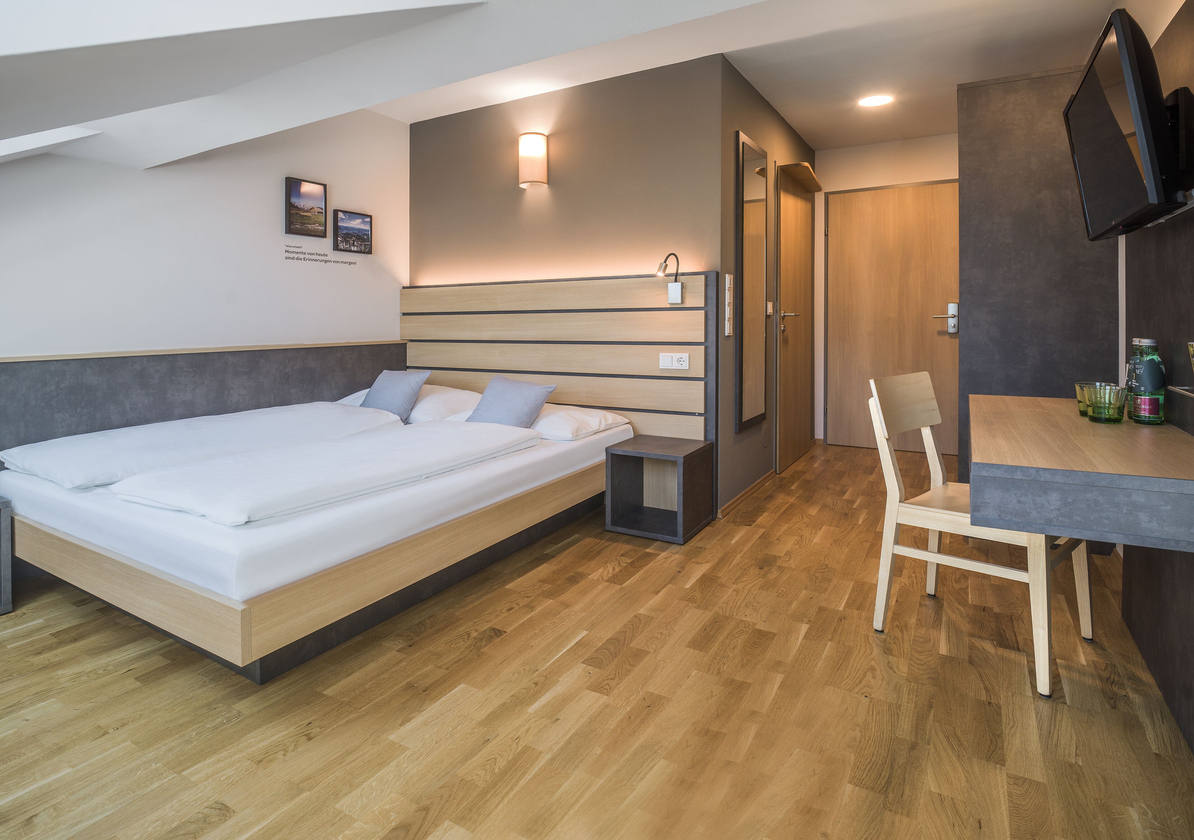 Quarto moderno com uma cama grande, uma escrivaninha e uma cadeira.