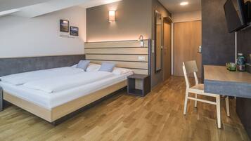 Quarto moderno com uma cama grande, uma escrivaninha e uma cadeira.
