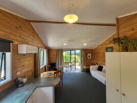 Um quarto acolhedor no estilo cabana, com área de jantar, sofá e cozinha compacta.