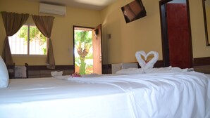 Quarto de hotel com cama, cortinas, janela e porta.