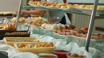 Buffet com diversos doces e sobremesas expostos em prateleiras de vidro.