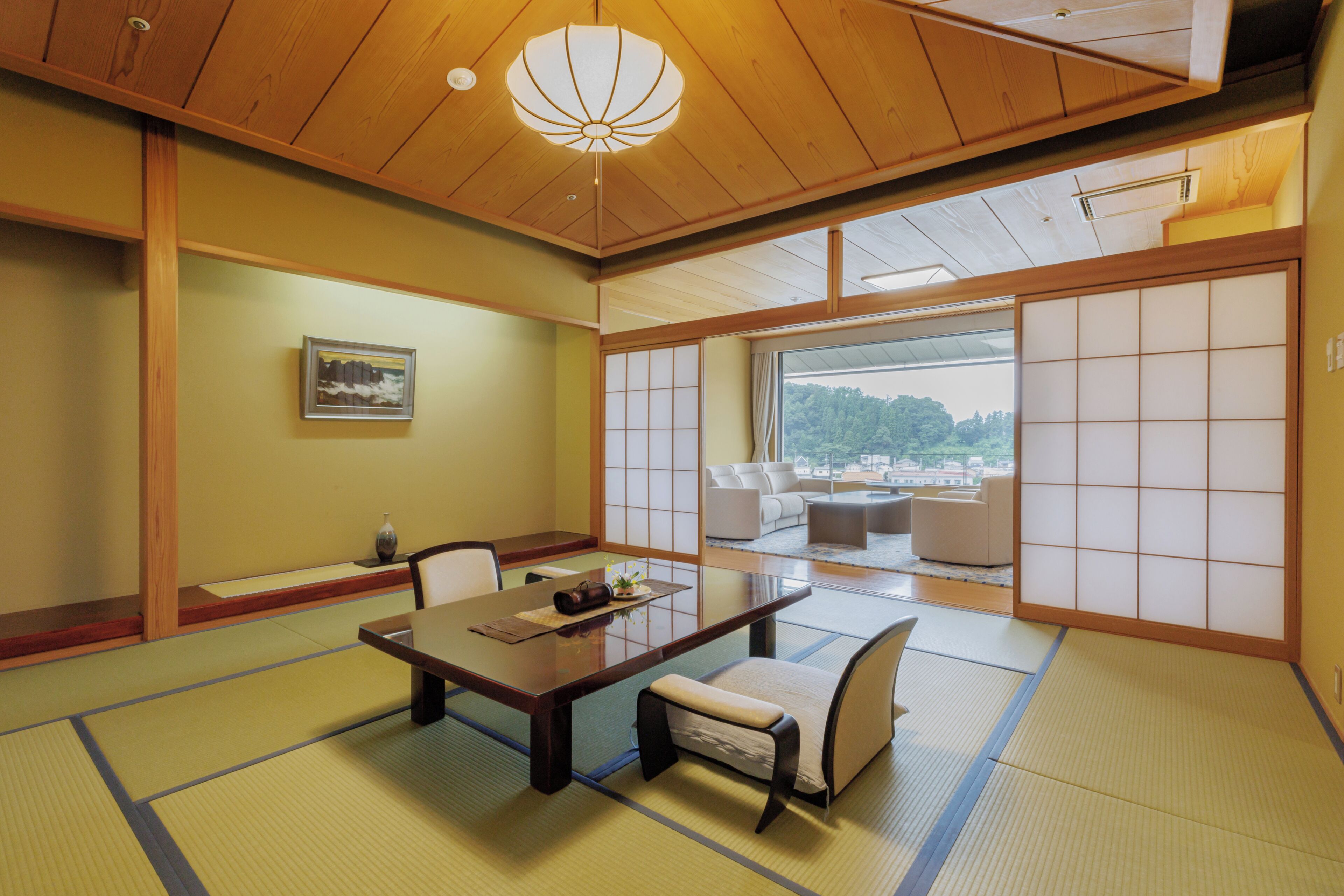 Um quarto japonês tradicional com tatames, uma mesa baixa e portas deslizantes.