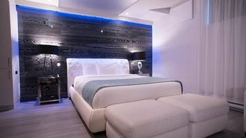 Quarto moderno com uma cama grande, mesas de cabeceira e um design de parede diferenciado.