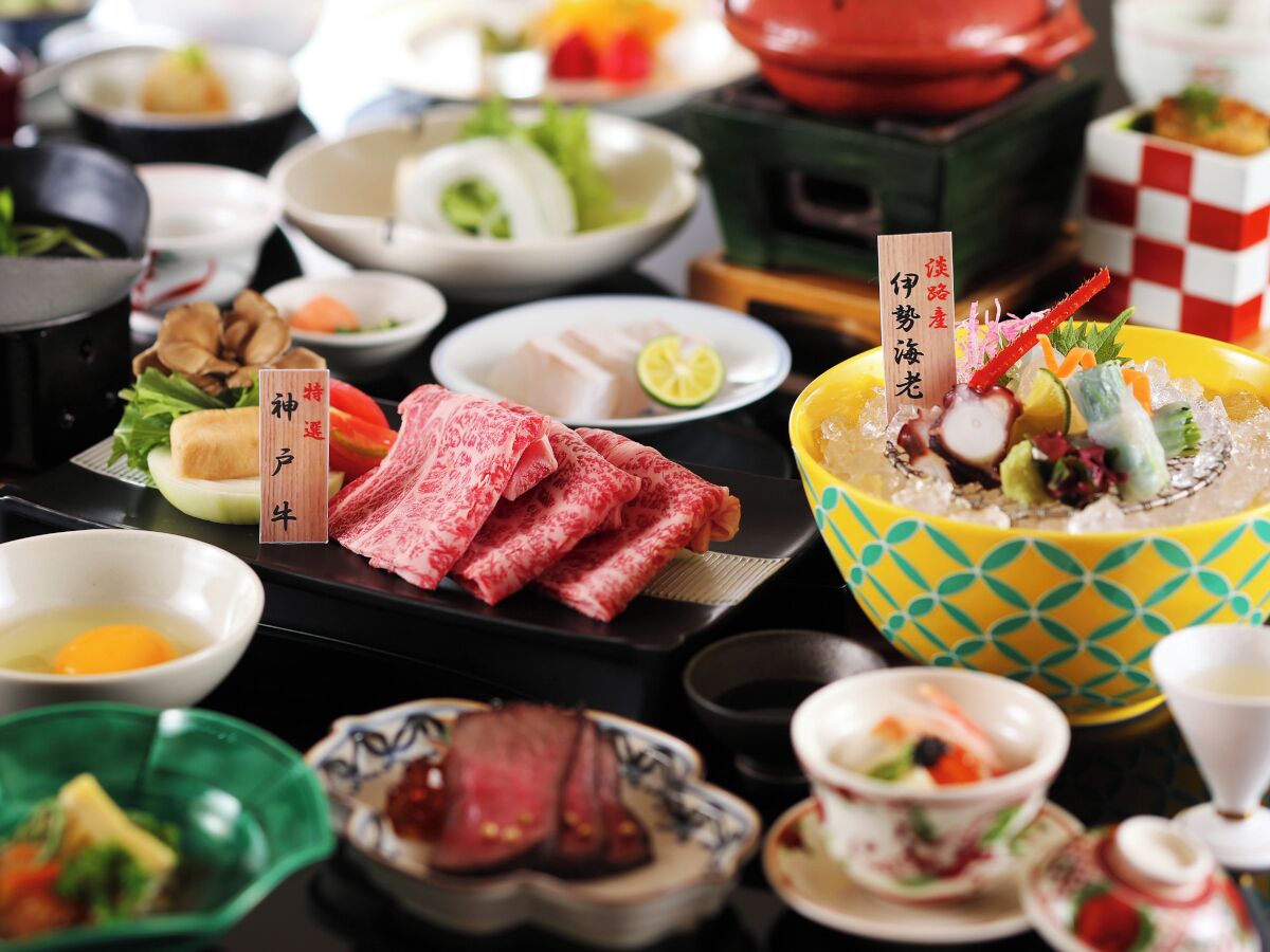 Diversos pratos, incluindo sashimi, uma tigela de sopa e um prato de carne.