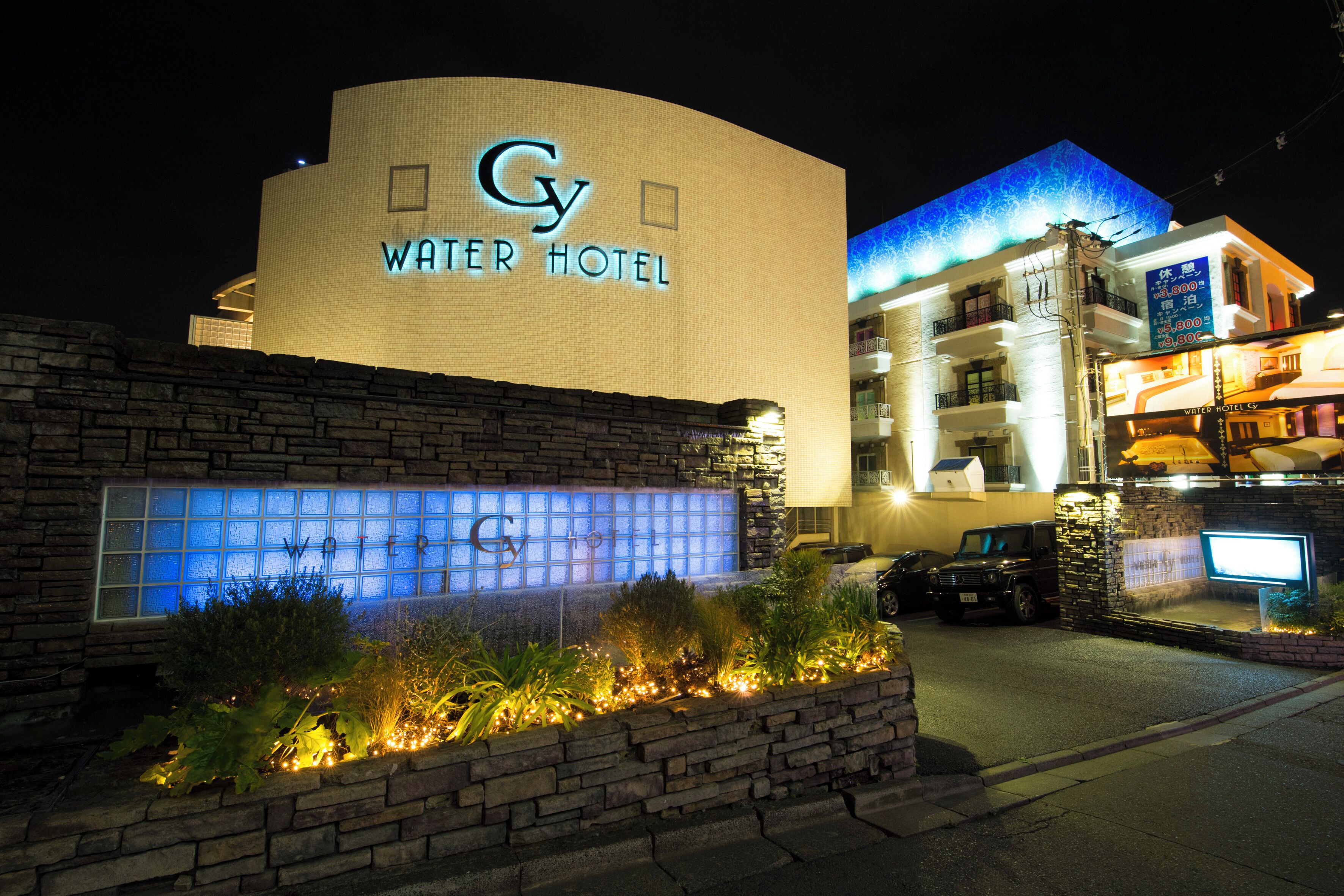Um hotel com um grande letreiro iluminado que diz 'Water Hotel'.