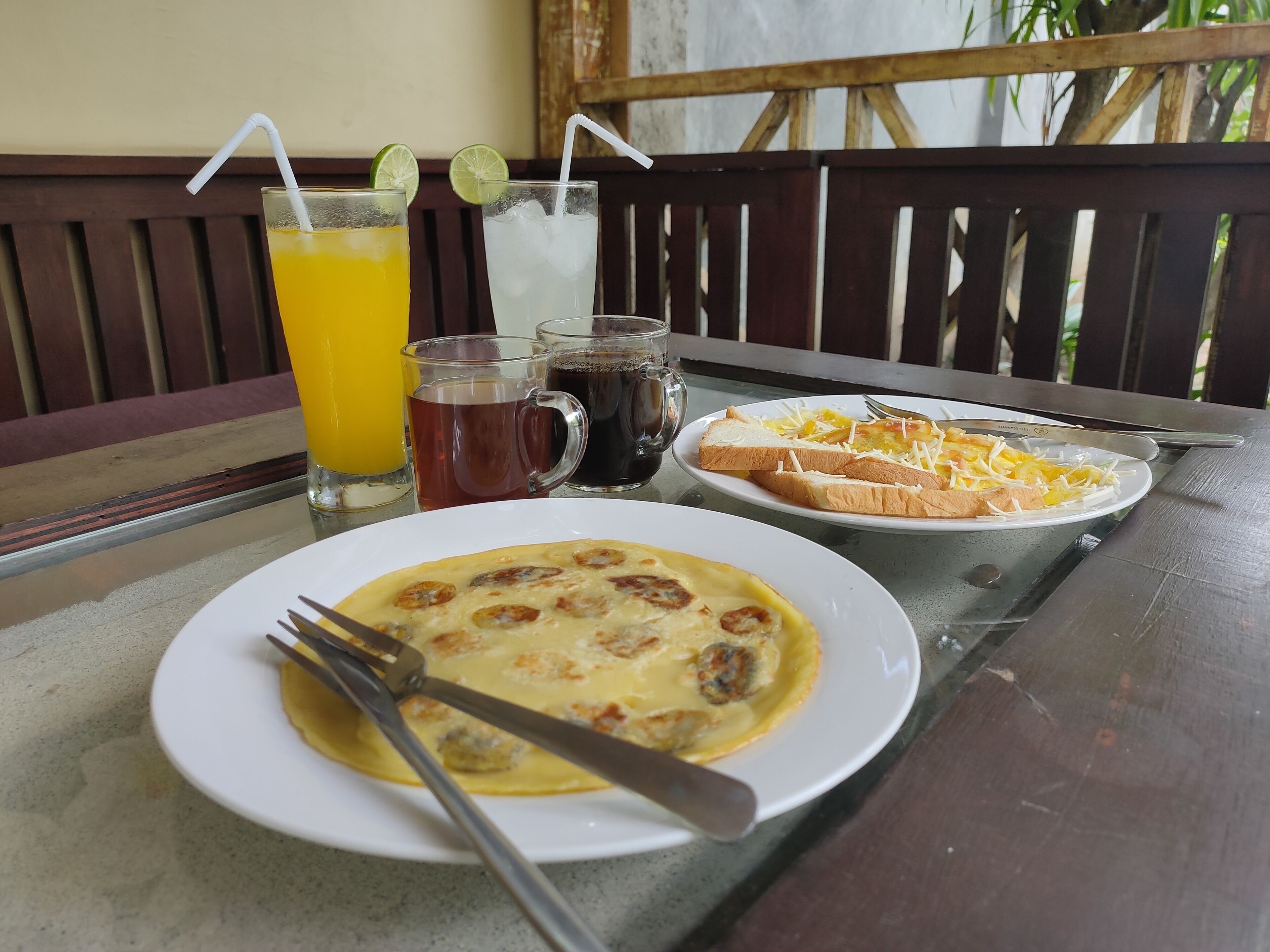 Uma mesa com um prato de comida, uma bebida e uma caneca.
