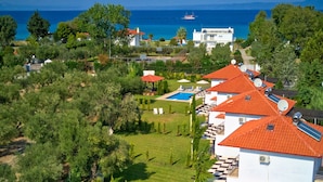 Um resort com piscina, espreguiçadeiras e vista para o mar.