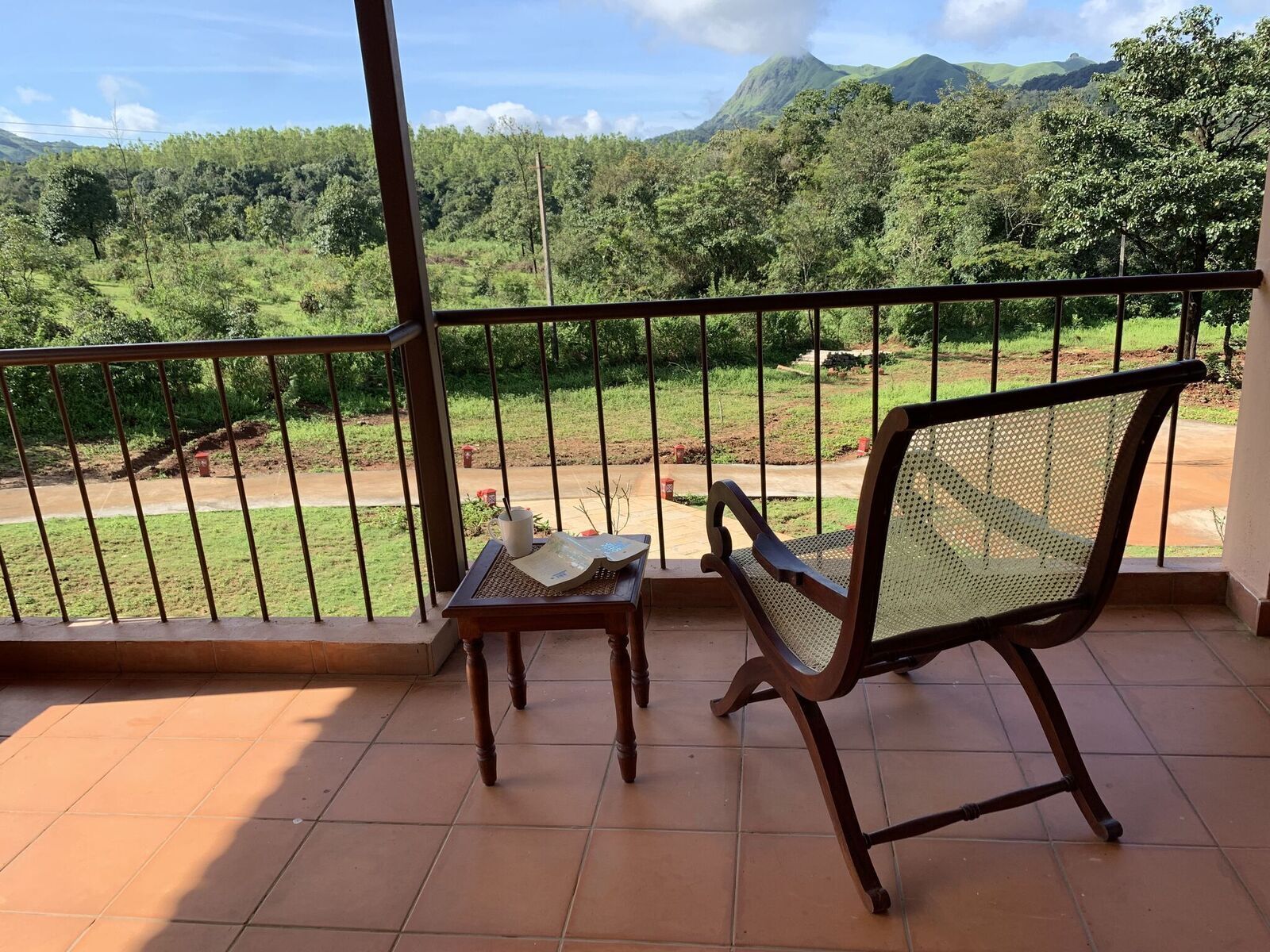 Uma varanda com vista para uma paisagem exuberante e montanhas.