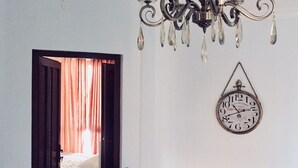 Uma escadaria com um candelabro e um relógio de parede.