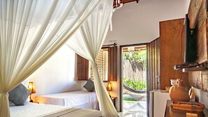 Quarto com cama, mesa de cabeceira, abajur e vista para o exterior.