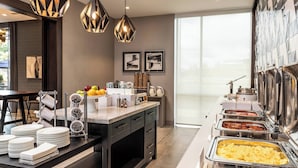 Uma cozinha moderna com serviço de buffet, incluindo pratos, tigelas e recipientes para alimentos.